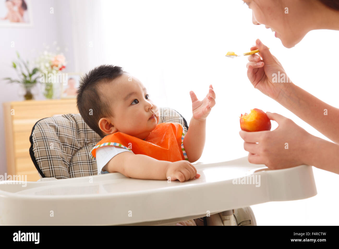 Mother feeds the baby to eat fruit Stock Photo - Alamy