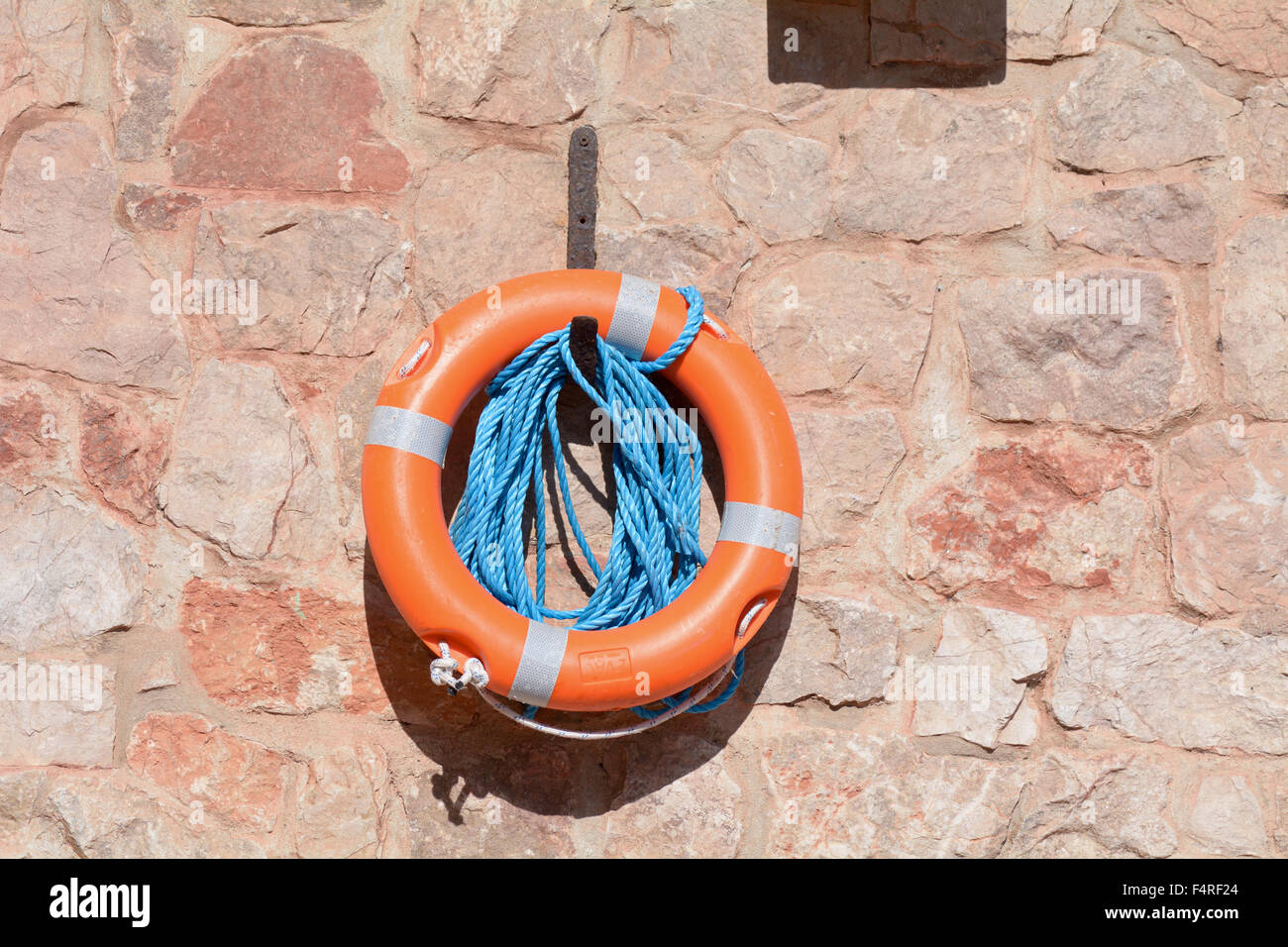 Orange life-preserver ring on a wall at Oddicombe Beach, Torquay, Devon ...