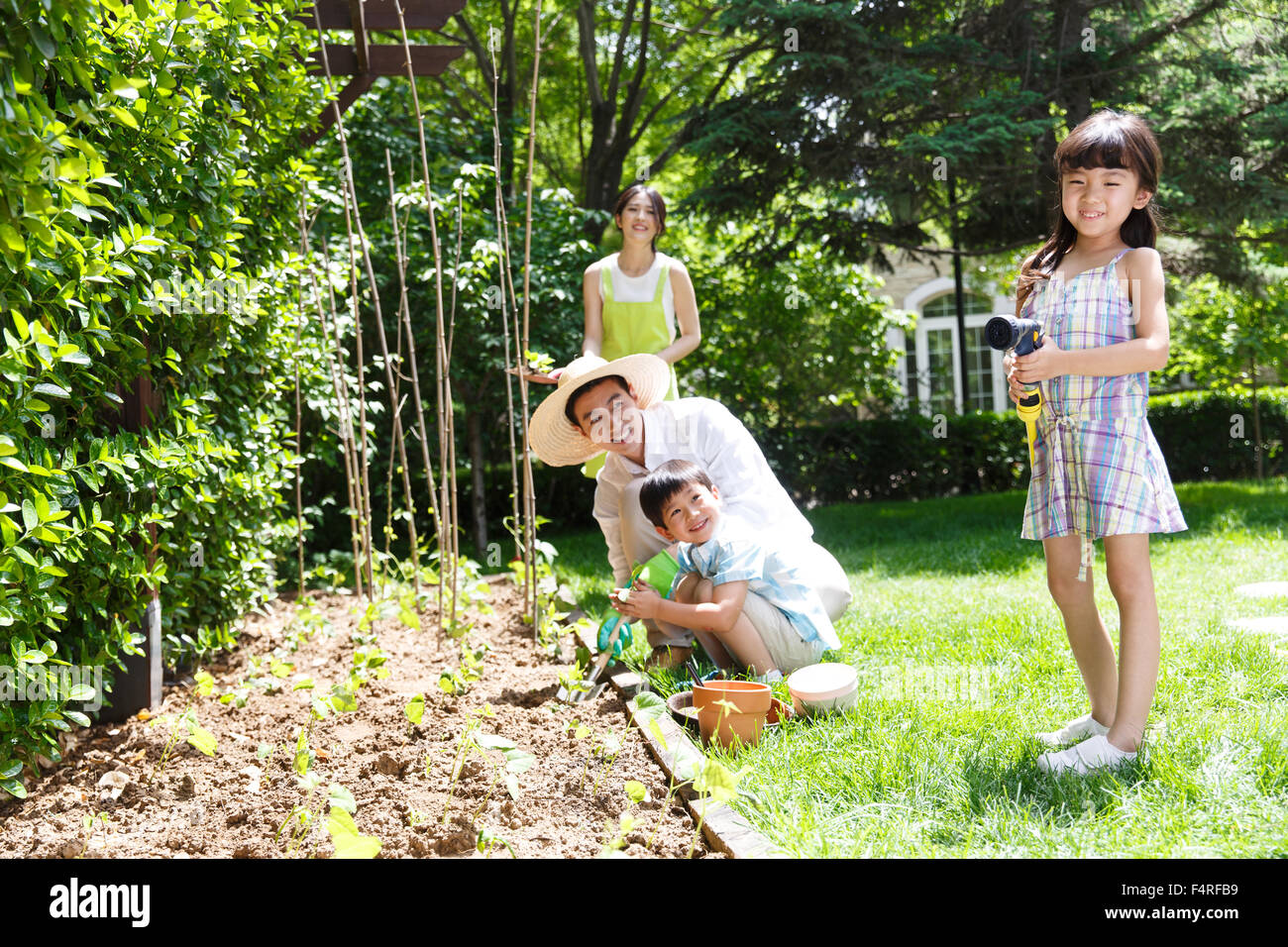 Happy family in the garden vegetables Stock Photo - Alamy