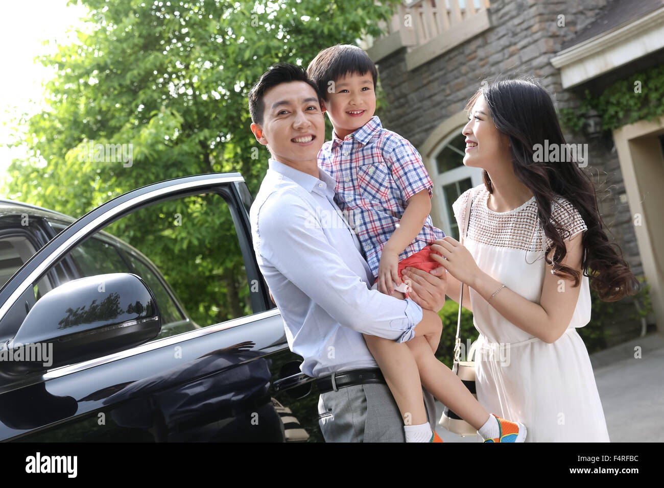 Happy family standing next to the car Stock Photo - Alamy