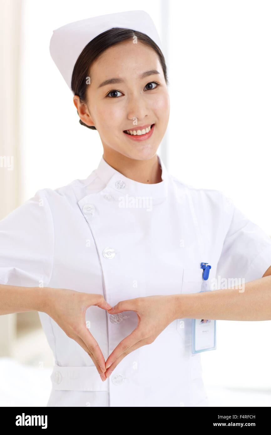 Young female nurses make a heart gesture Stock Photo - Alamy