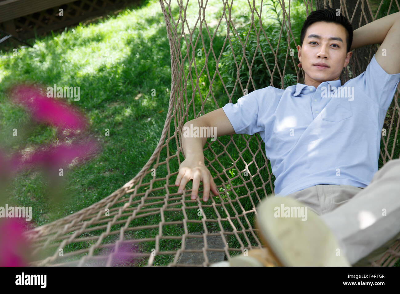 Casual young men lying in a hammock Stock Photo - Alamy