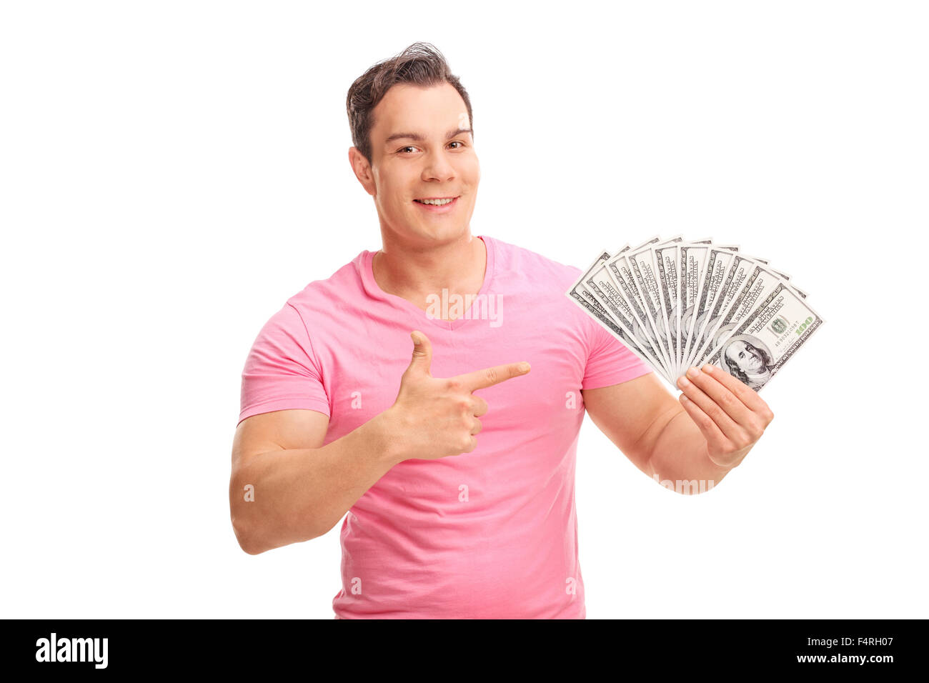 Young man holding a stack of money in one hand and pointing towards ...