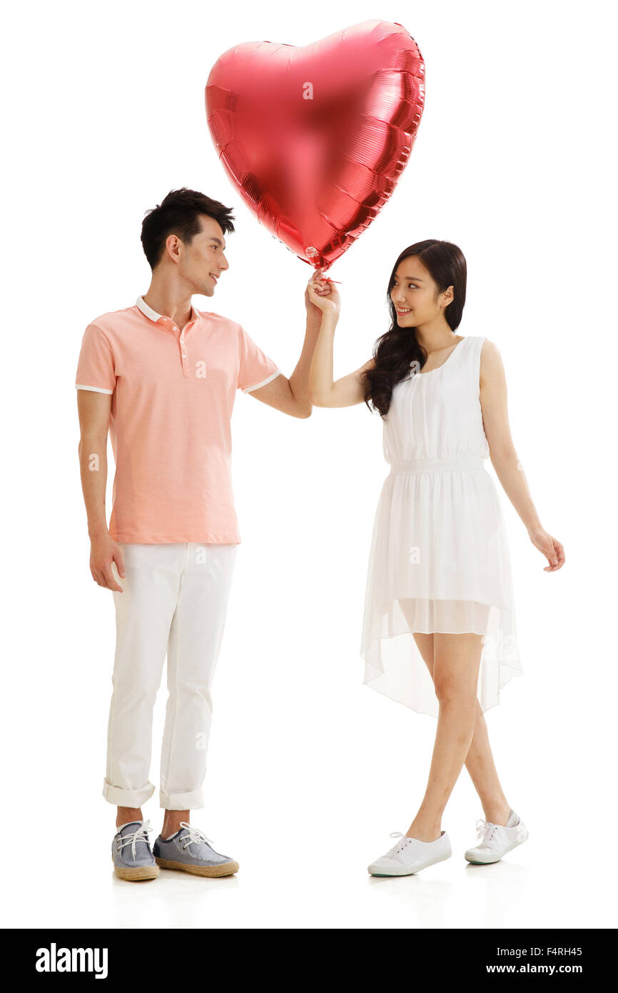 Happy couples holding a balloon Stock Photo - Alamy
