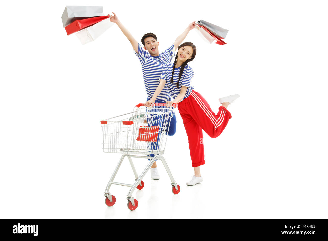 Happy young men and women push shopping cart Stock Photo - Alamy