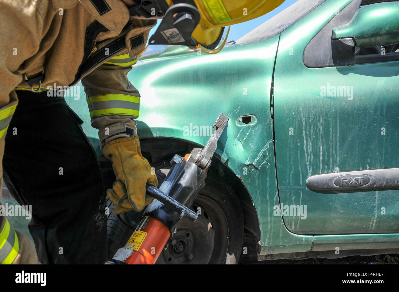 Firefighters use power tools to rescue trapped passengers from a car ...