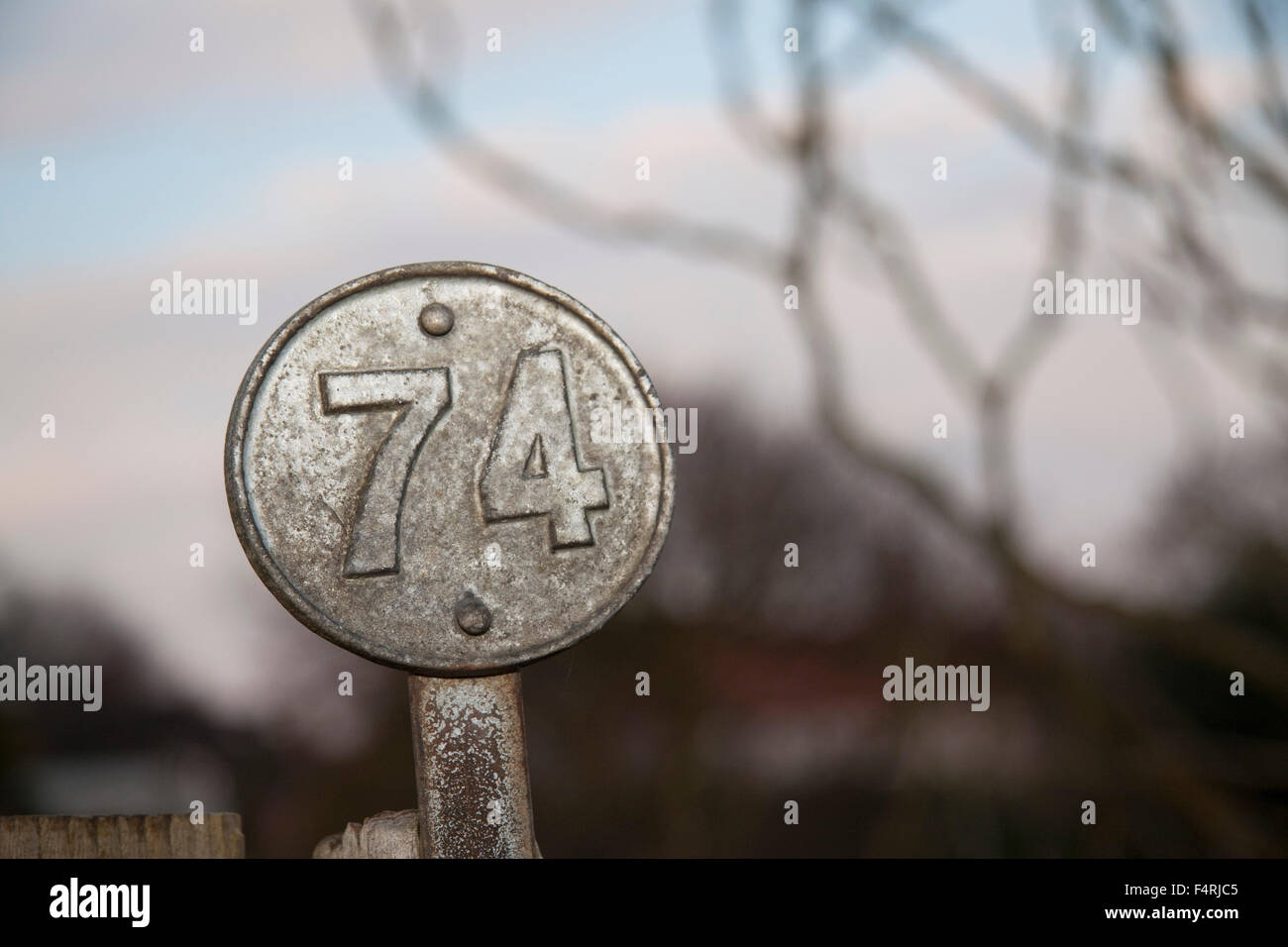 Cast metal number 74 plot marker Stock Photo - Alamy