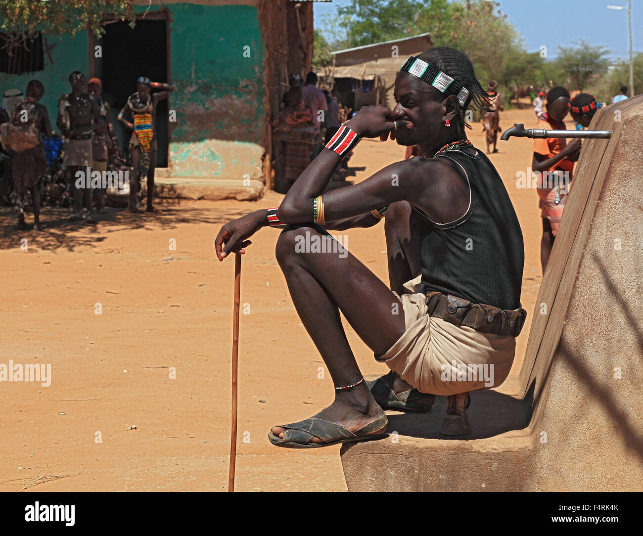 Omo region, in the village of Turmi, young man sitting at the watering ...