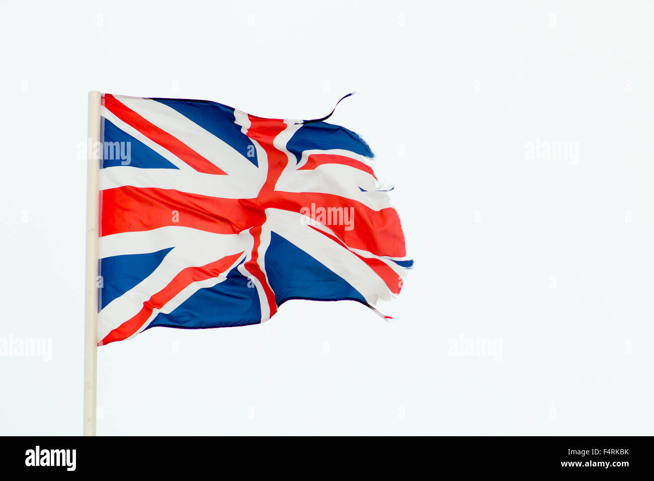 Union Jack fluttering on a flag pole. Grey sky on background Stock ...