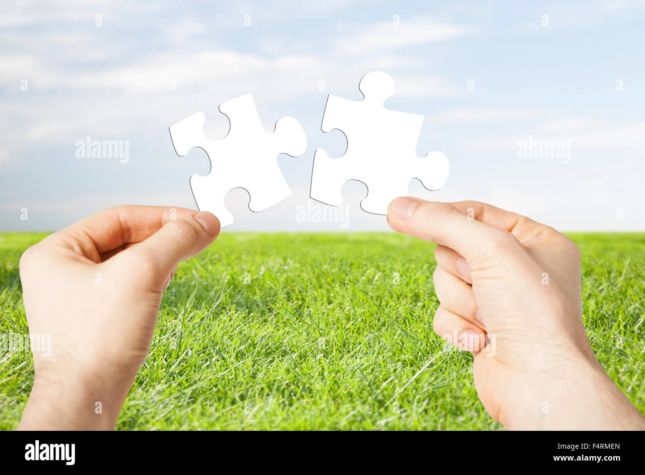 two hands trying to connect puzzle pieces Stock Photo - Alamy