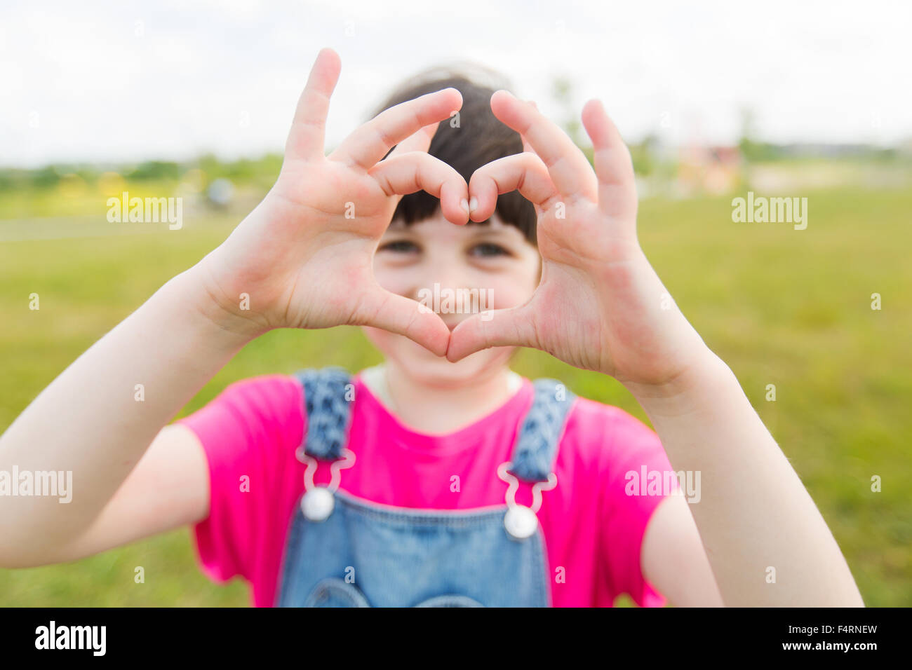 happy little girl making heart shape gesture Stock Photo - Alamy
