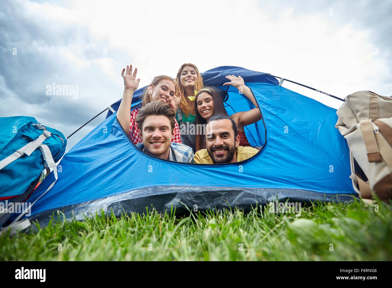 happy friends with backpacks in tent at camping Stock Photo - Alamy