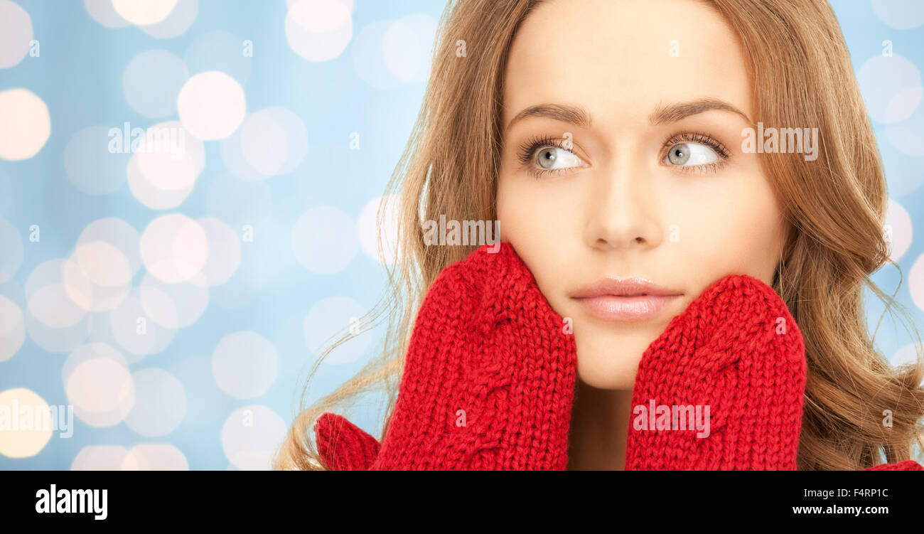 happy young woman in red mittens over blue lights Stock Photo - Alamy