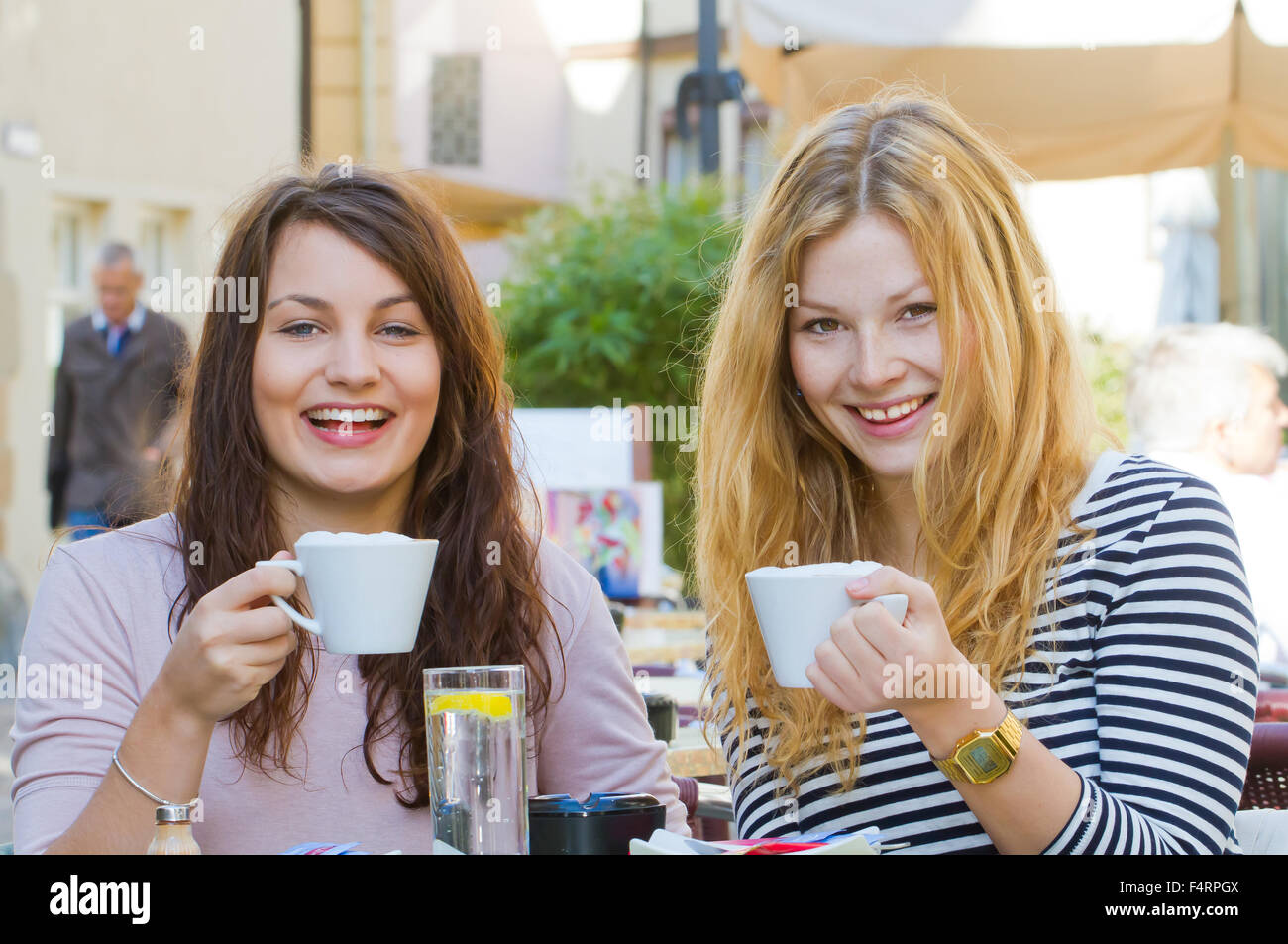 Two happy girls drinking coffee Stock Photo - Alamy