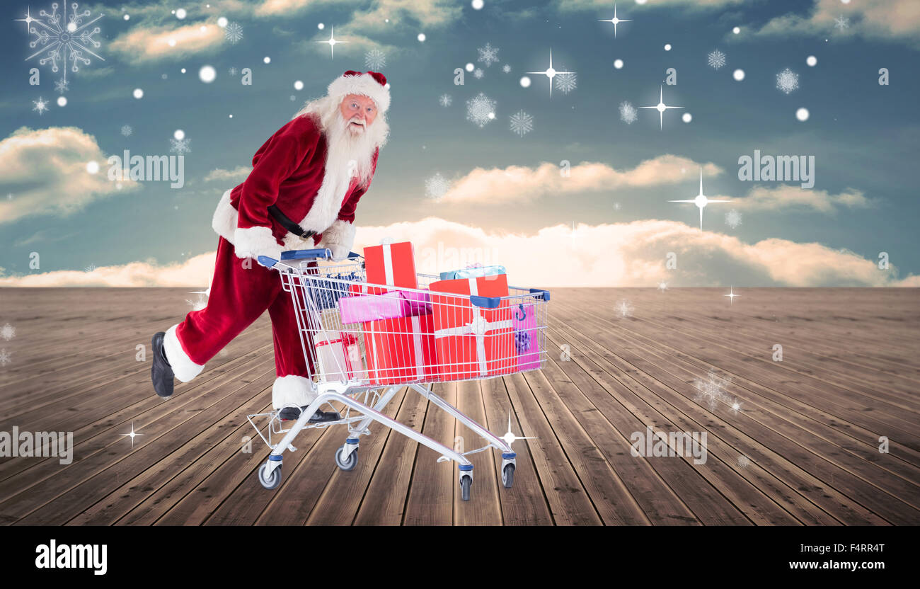 Composite image of santa pushing shopping cart Stock Photo - Alamy
