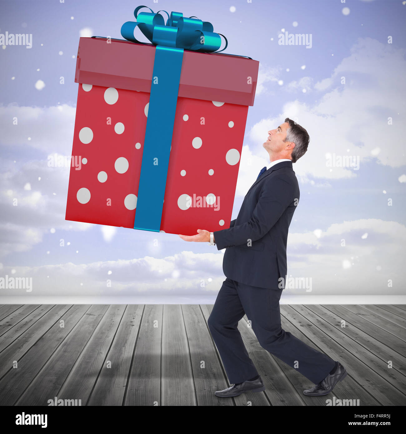 Composite image of stylish man with giant gift Stock Photo - Alamy
