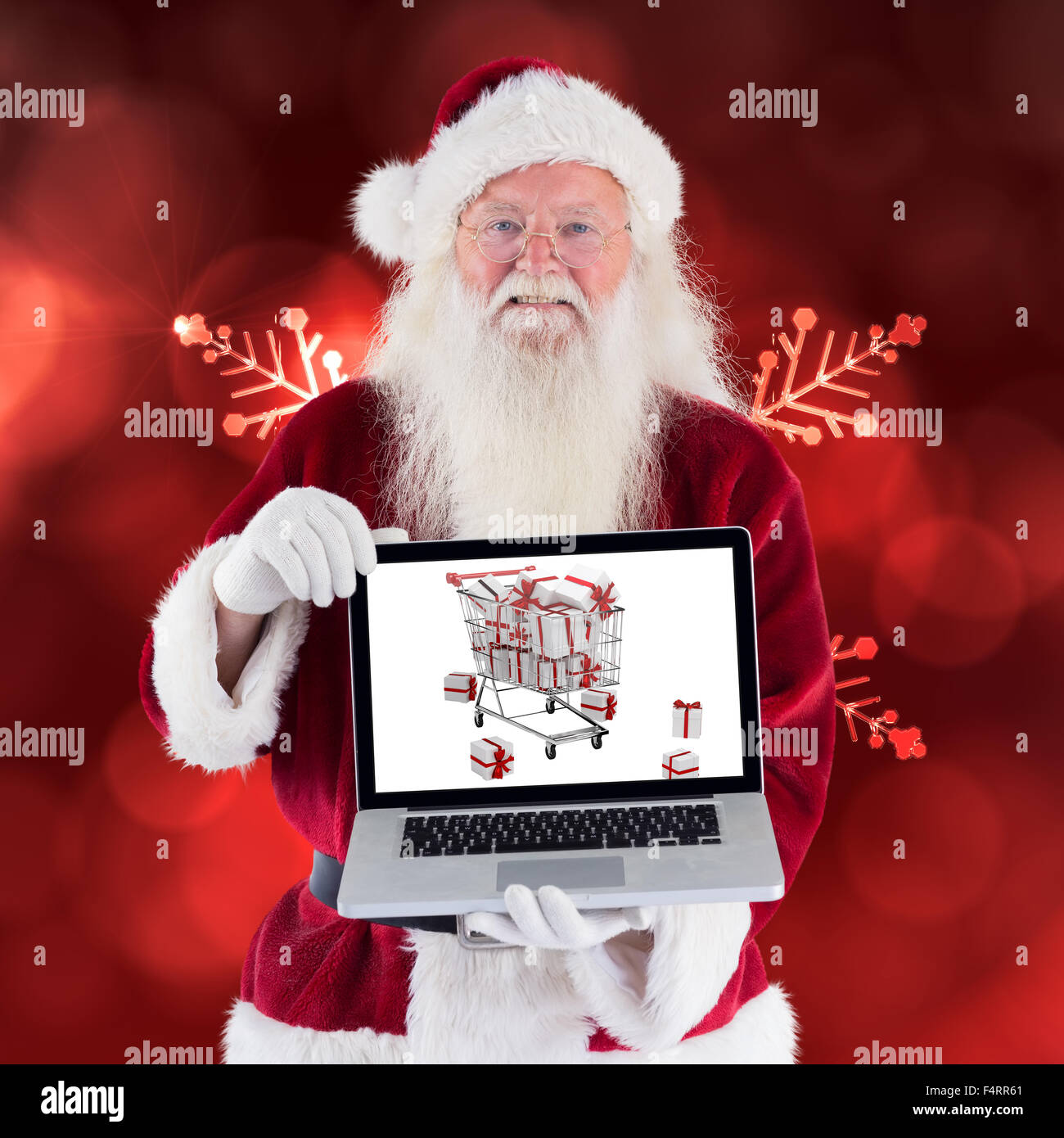 Composite image of santa claus presents a laptop Stock Photo - Alamy