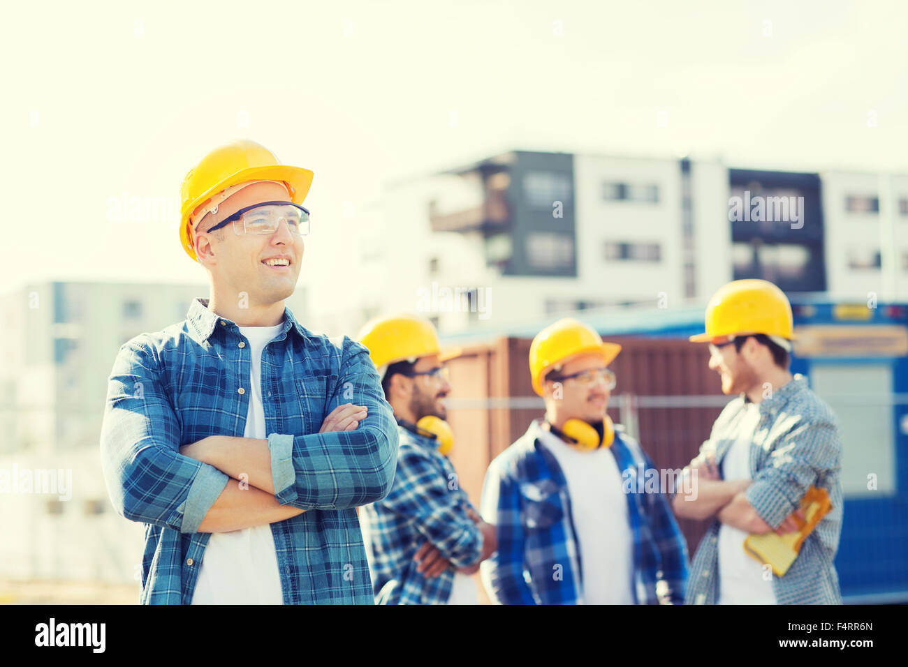 group of smiling builders in hardhats outdoors Stock Photo - Alamy
