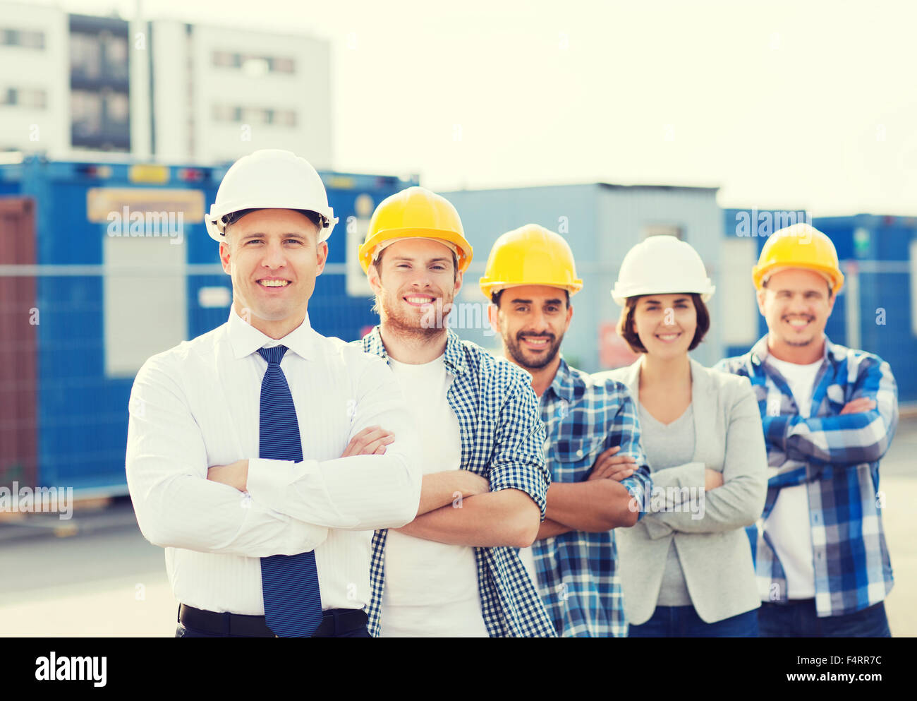 group of smiling builders in hardhats outdoors Stock Photo - Alamy
