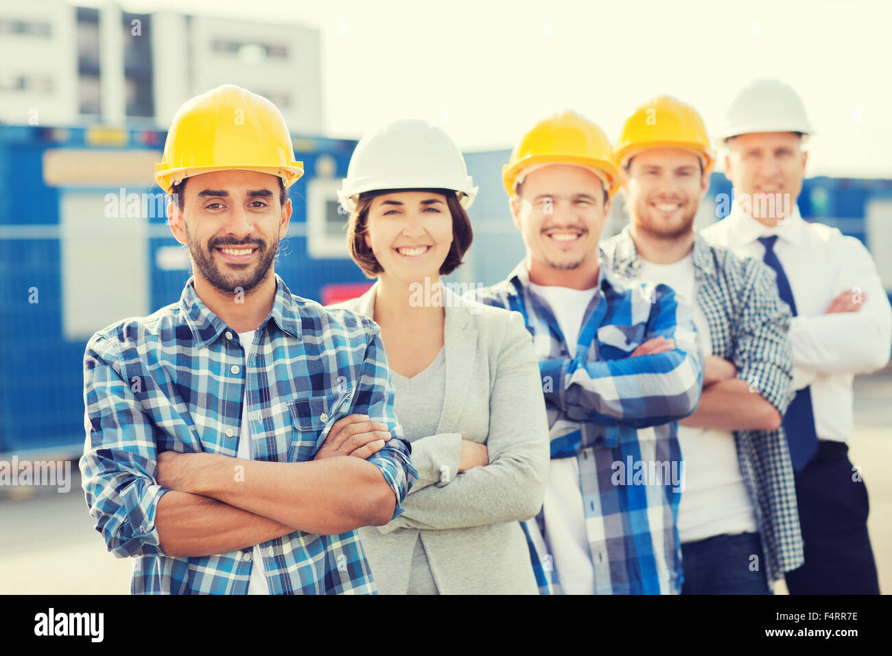 group of smiling builders in hardhats outdoors Stock Photo - Alamy