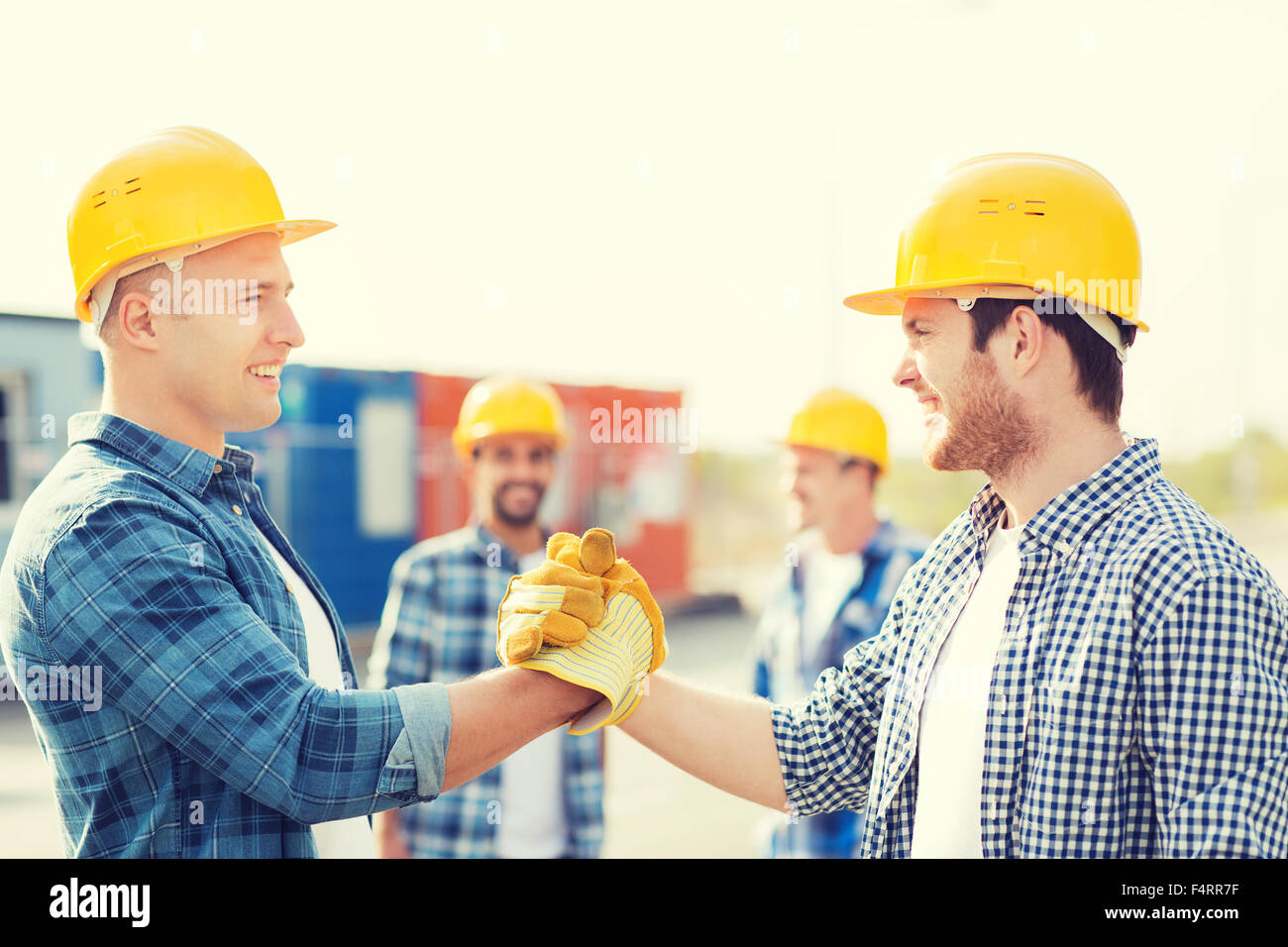 group of smiling builders in hardhats outdoors Stock Photo - Alamy