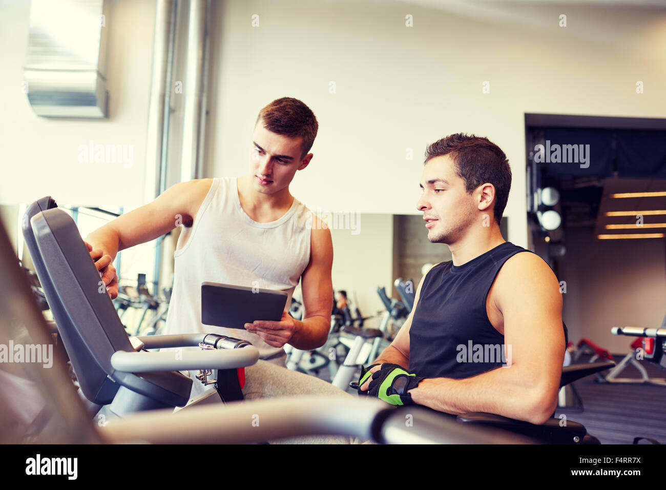 men exercising on gym machine Stock Photo - Alamy