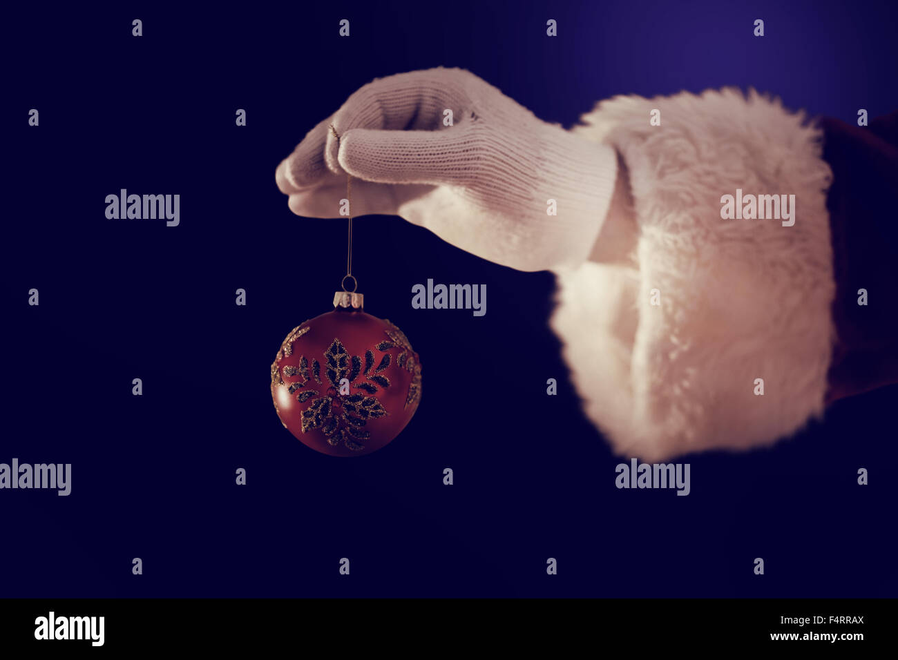 Santas hand is holding a Christmas bulb Stock Photo - Alamy