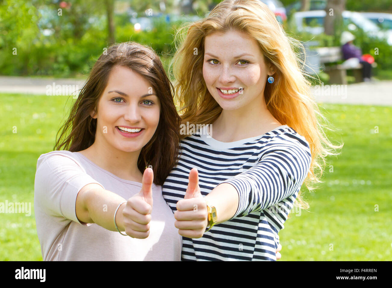 Two happy girls with thumbs up Stock Photo - Alamy