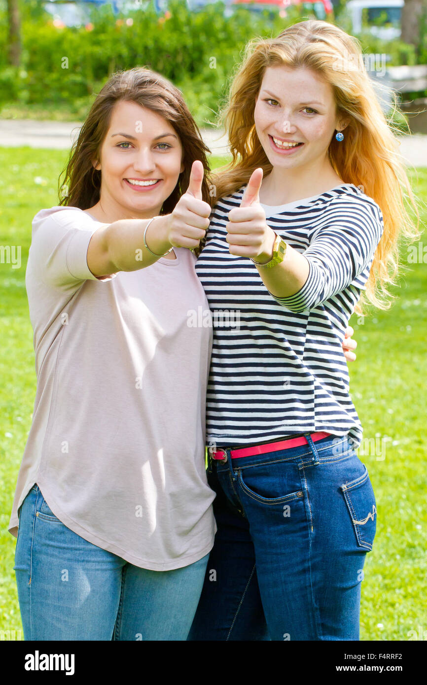 Two happy girls with thumbs up Stock Photo - Alamy