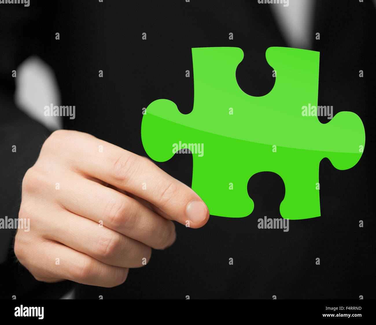 hand holding a green puzzle piece Stock Photo - Alamy