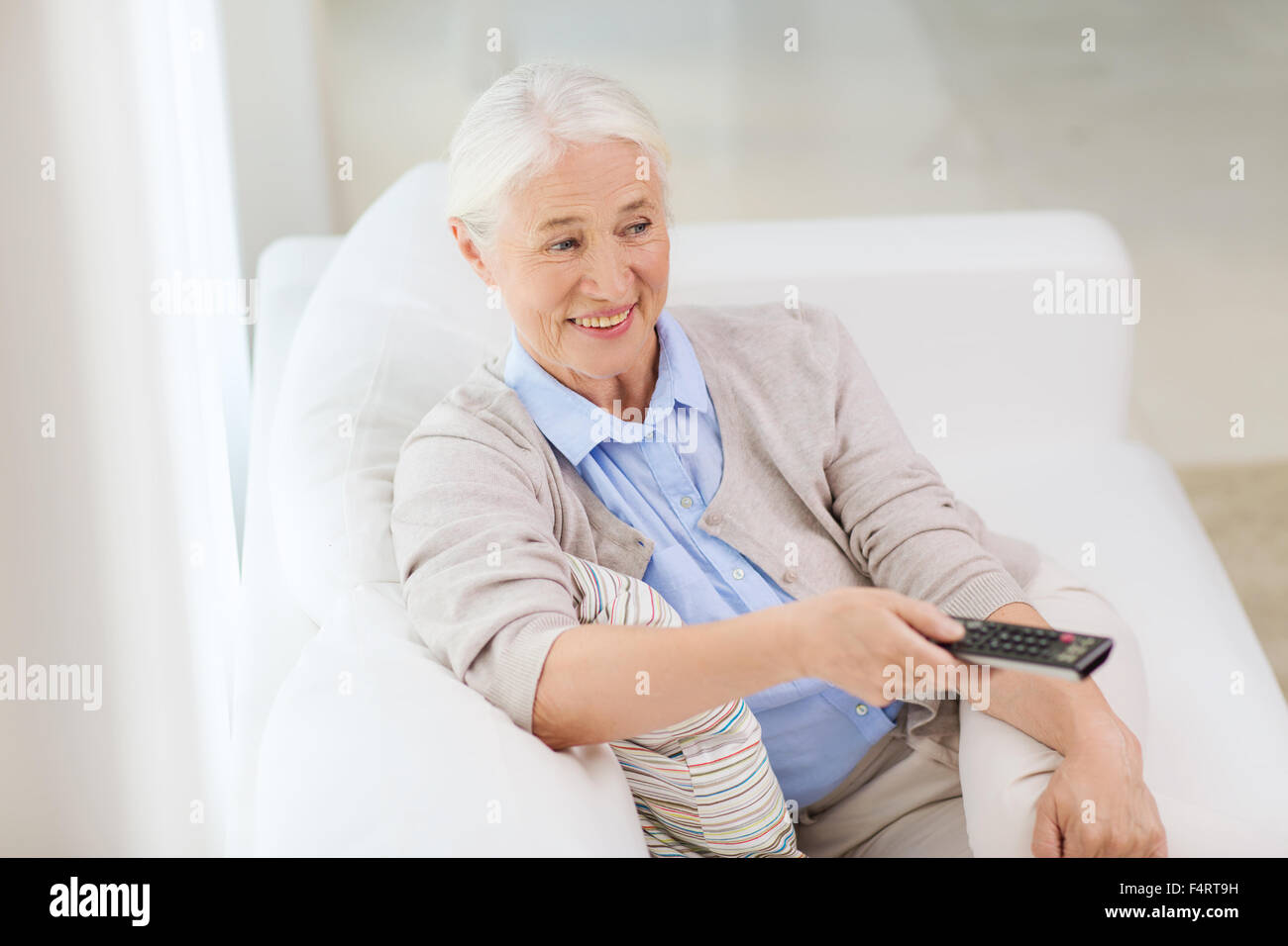 happy senior woman watching tv at home Stock Photo - Alamy