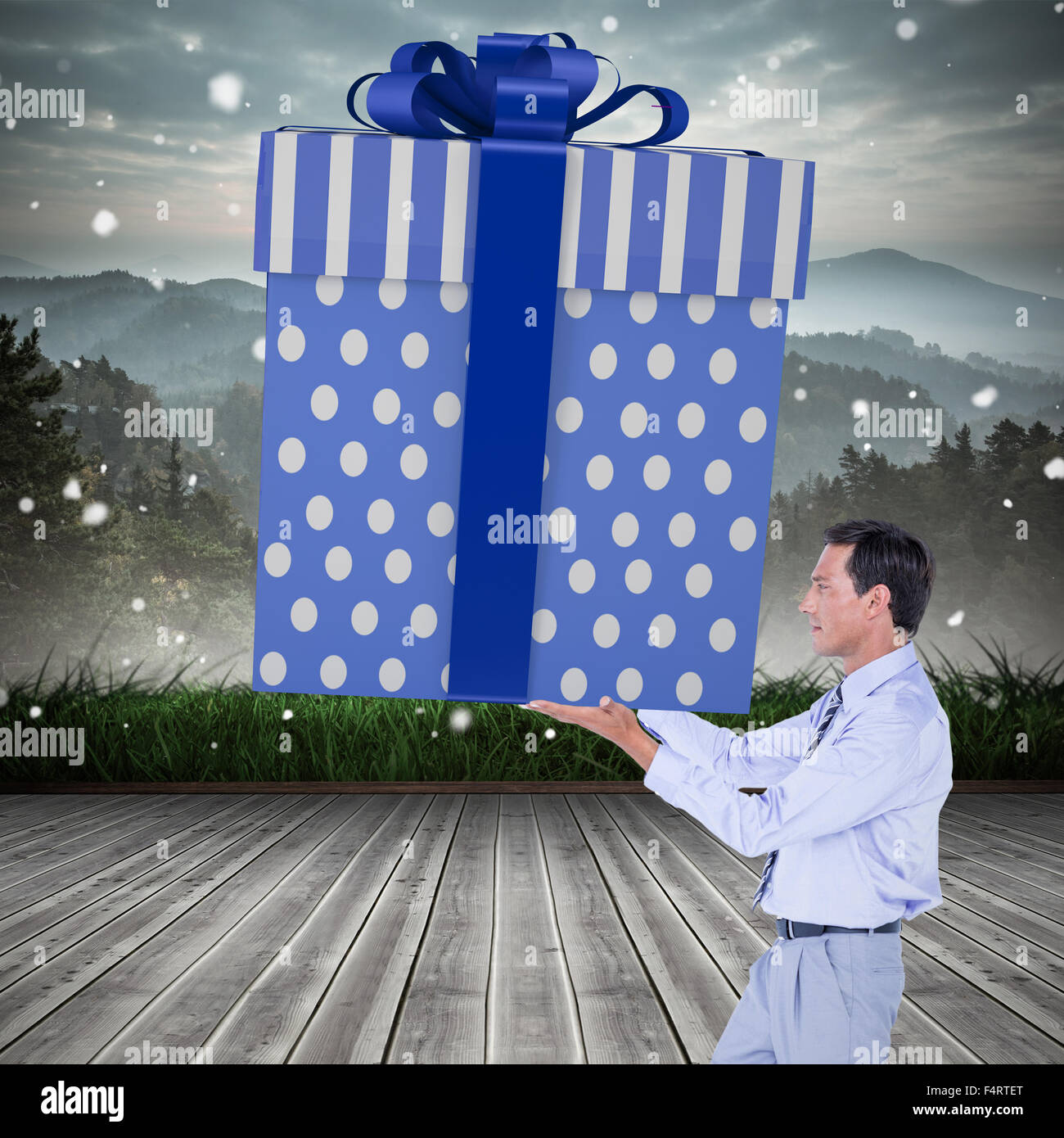 Composite image of stylish man with giant gift Stock Photo - Alamy