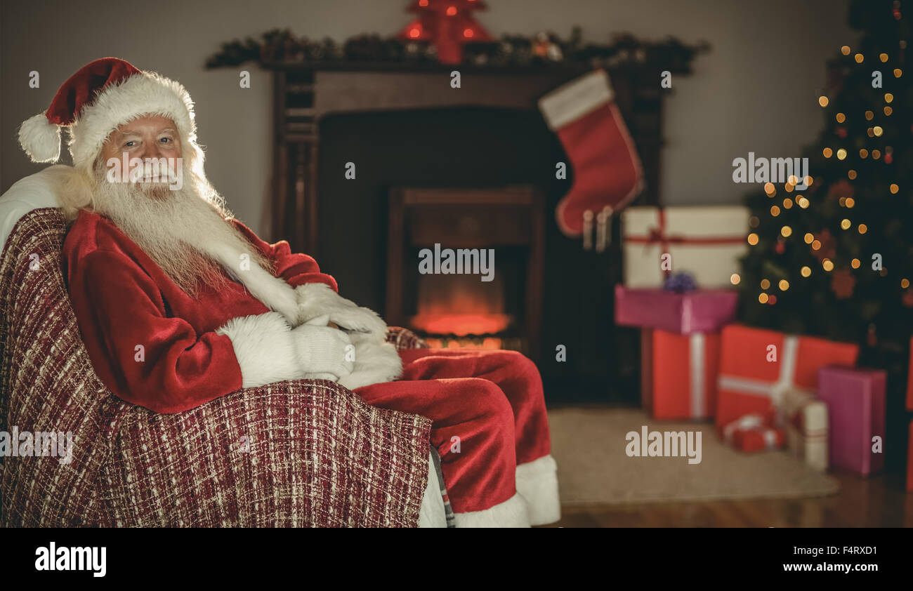 Festive santa claus sitting on couch at christmas Stock Photo - Alamy