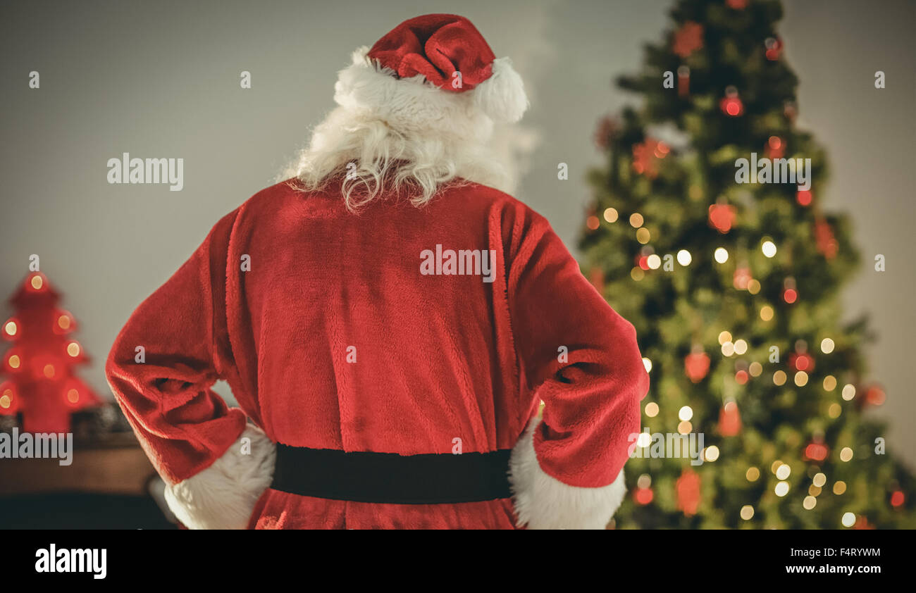 Rear view of santa standing in front of the christmas tree Stock Photo ...