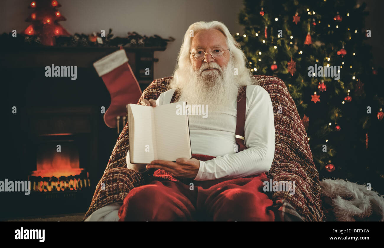 Santa claus showing his book Stock Photo - Alamy