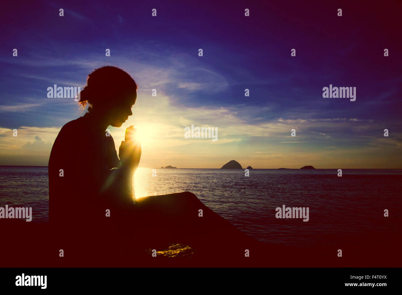 Young woman praying sunset over the Ocean Concept Stock Photo - Alamy