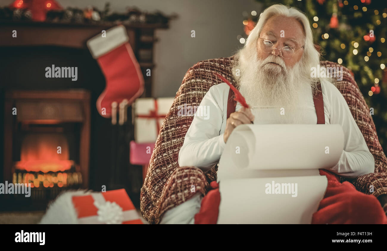 Relaxed santa writing list with a quill Stock Photo - Alamy