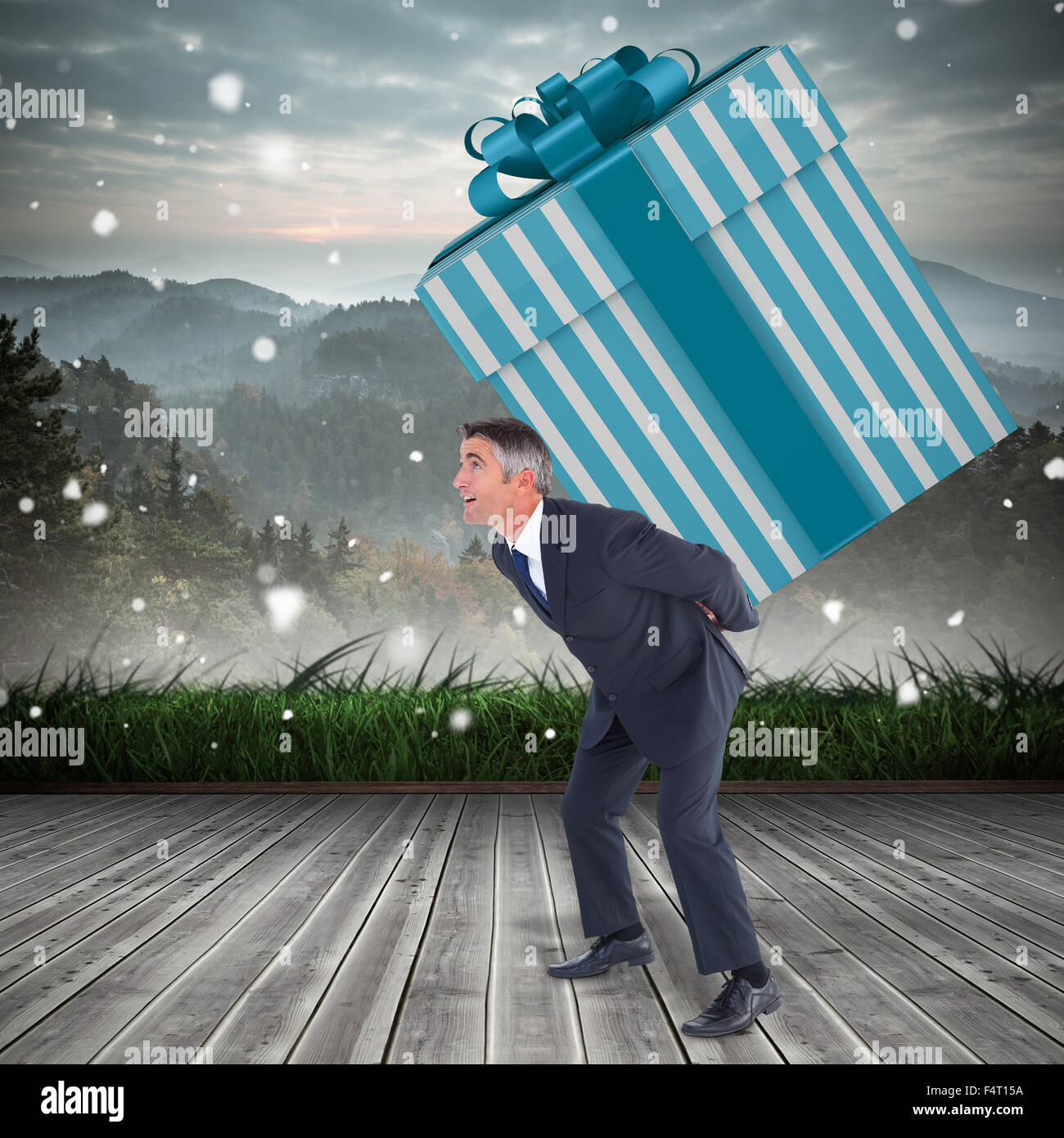 Composite image of stylish man with giant gift Stock Photo - Alamy