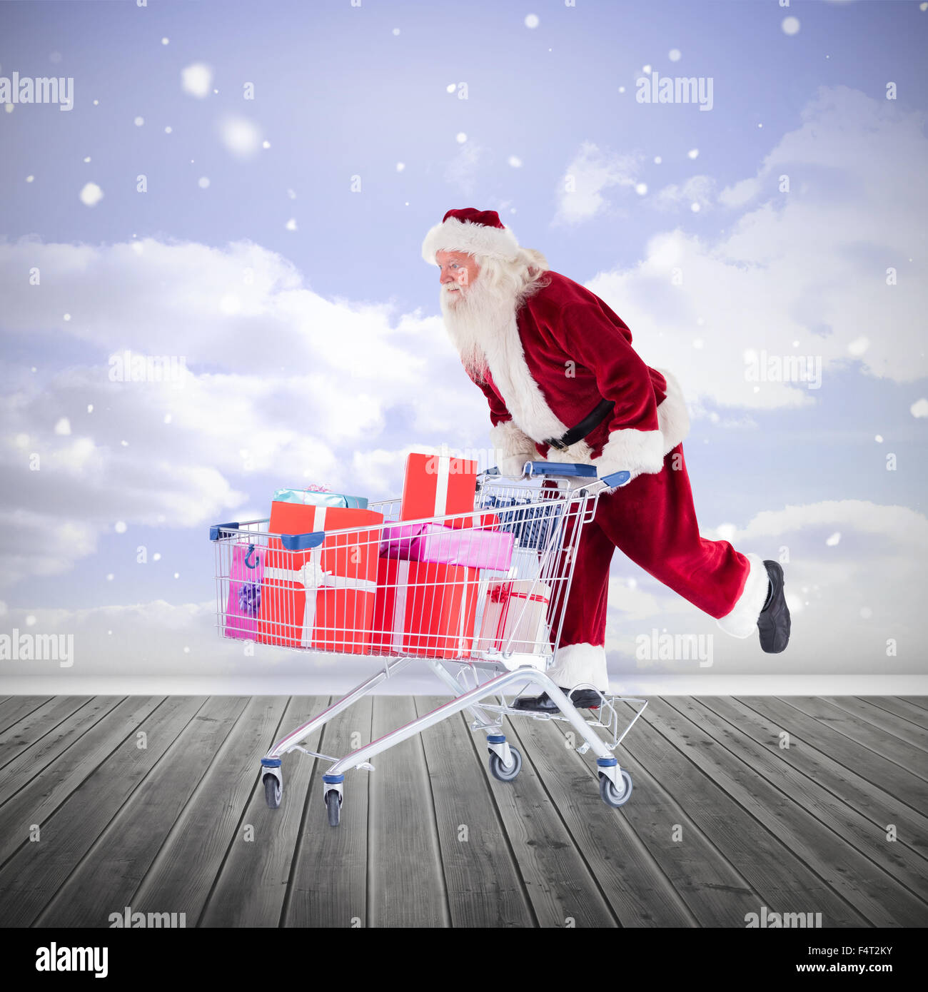 Composite image of santa pushing a shopping cart Stock Photo - Alamy