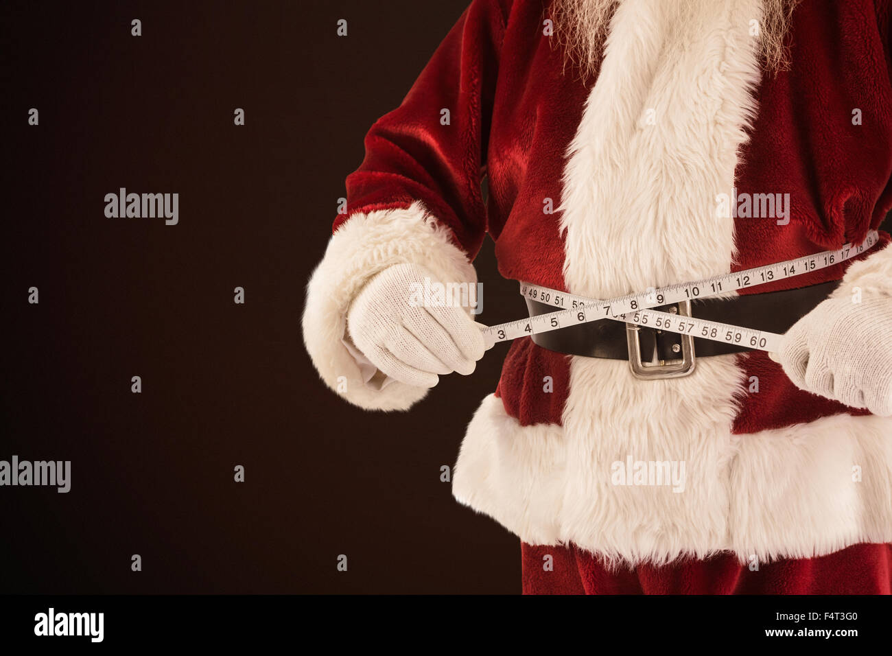 Composite image of santa claus measures his belly Stock Photo - Alamy