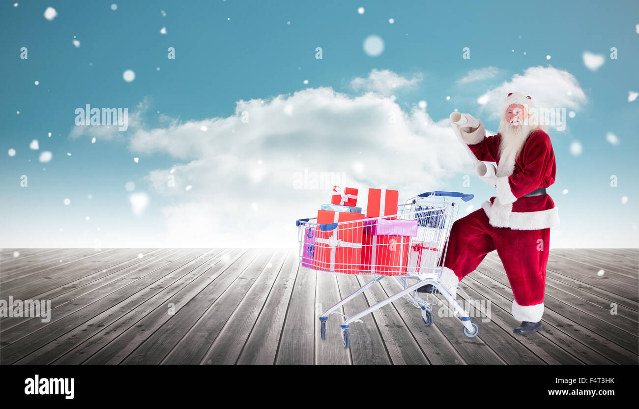 Composite image of santa delivering gifts from cart Stock Photo - Alamy