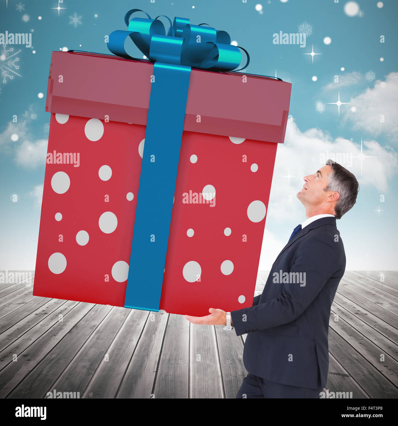 Composite image of stylish man with giant gift Stock Photo - Alamy
