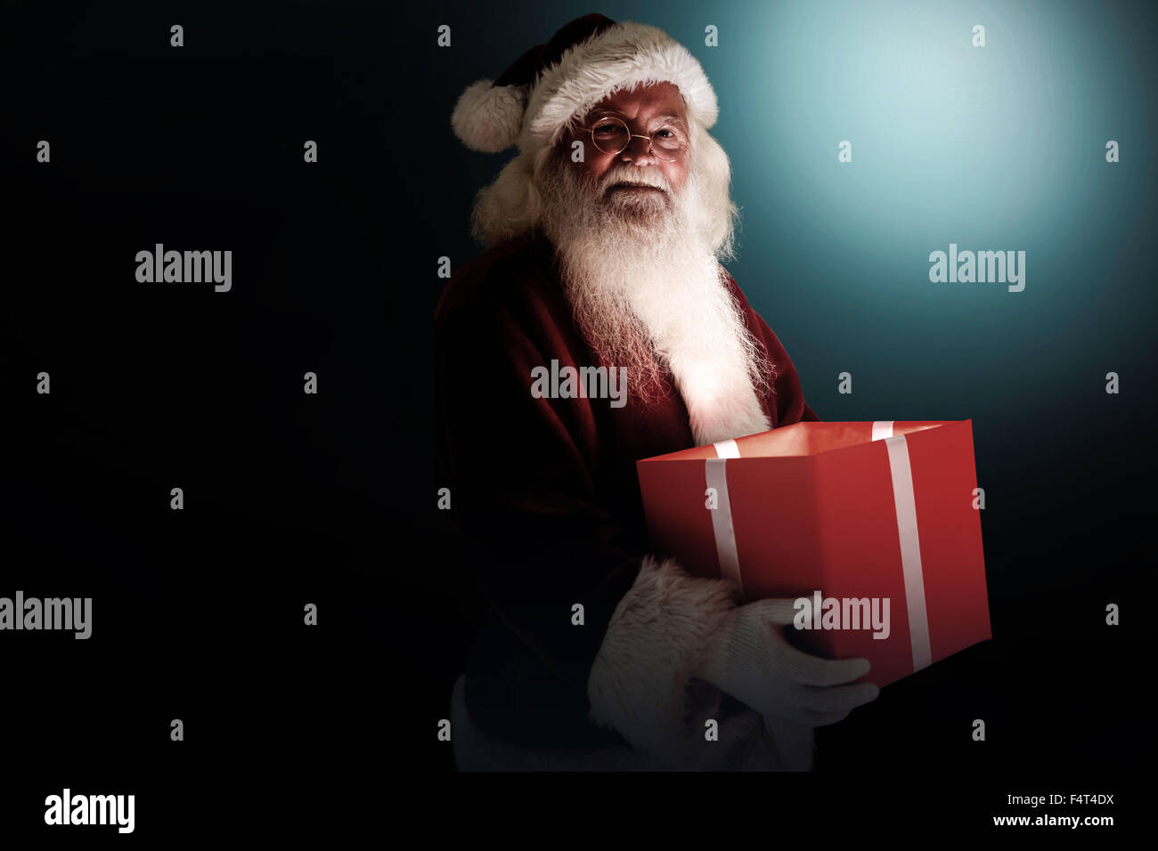 Father christmas holding a gift Stock Photo - Alamy