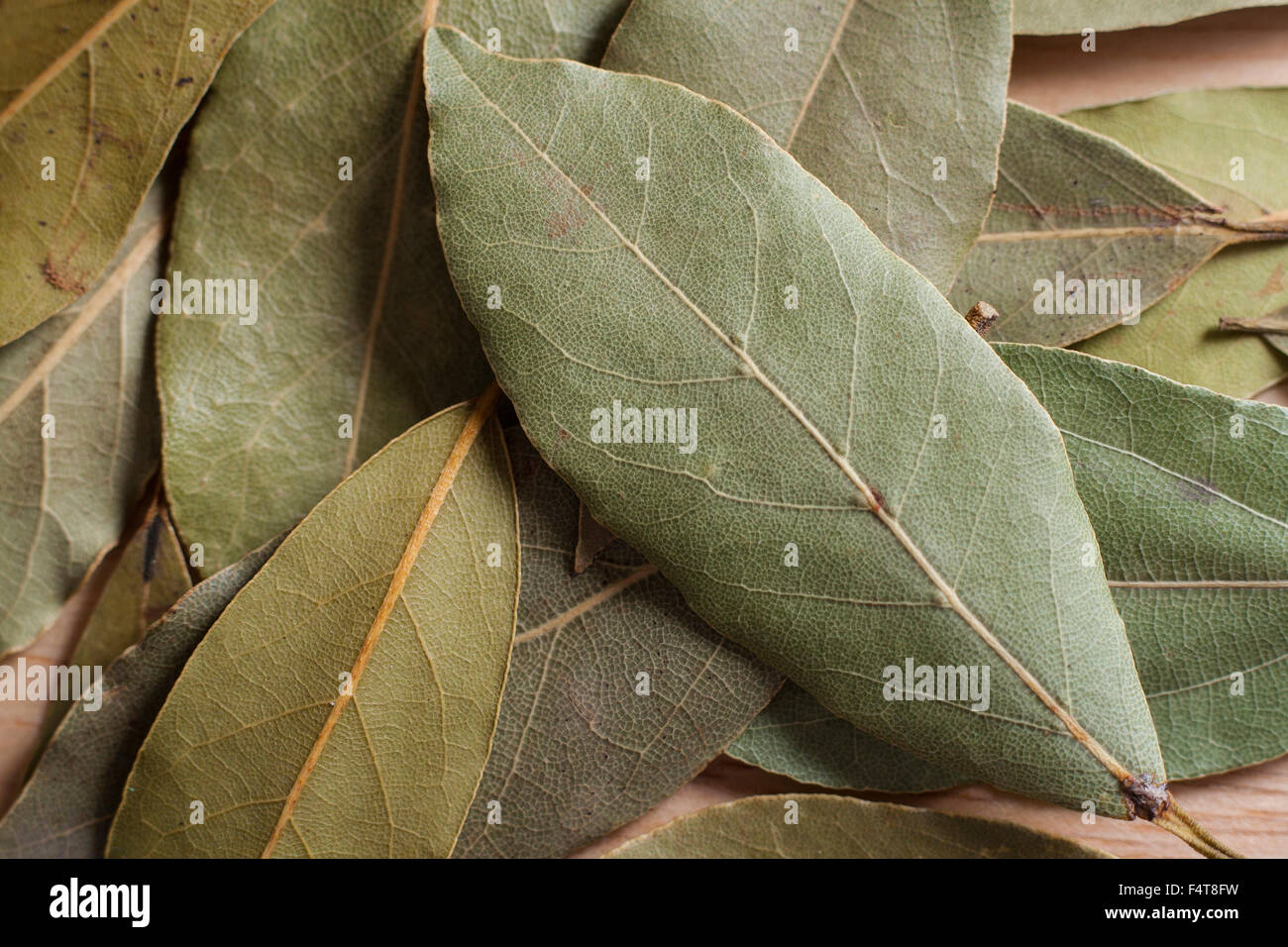 Dry bay leaves spilled on wooden board Stock Photo - Alamy