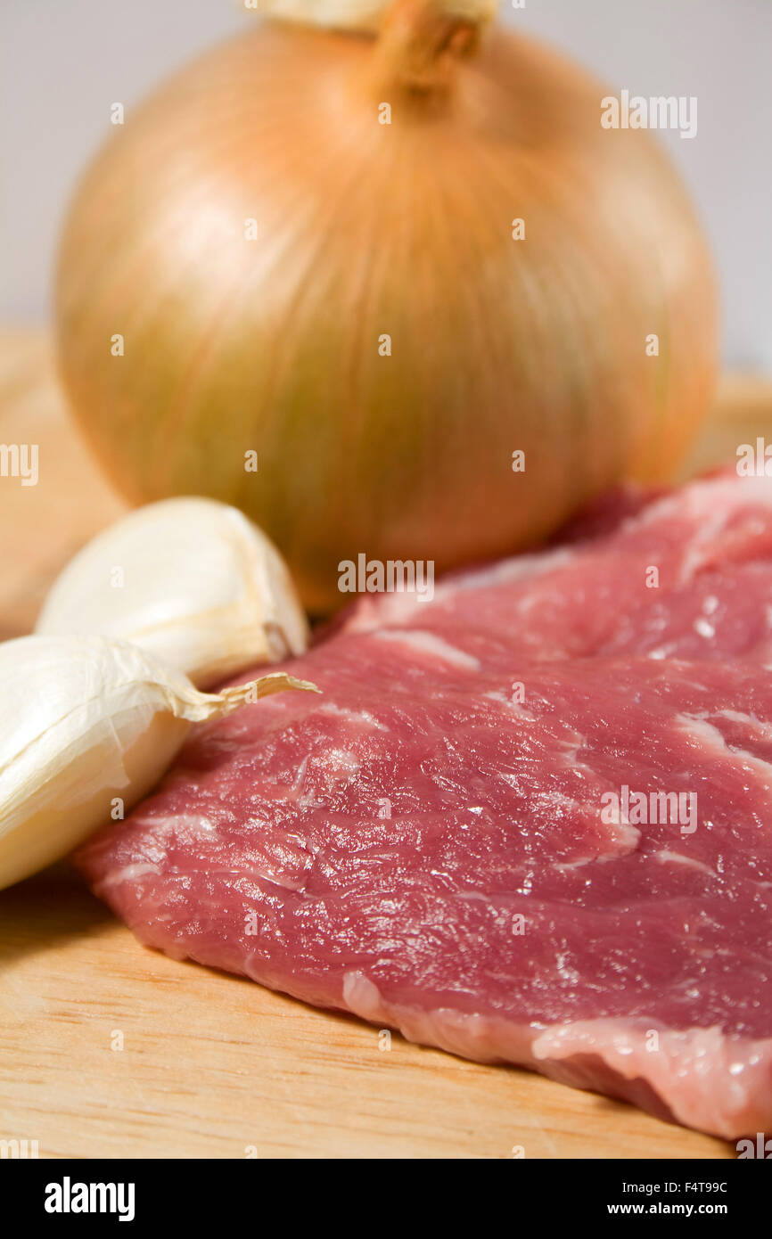 Raw meat chop with two garlic cloves and onion Stock Photo - Alamy