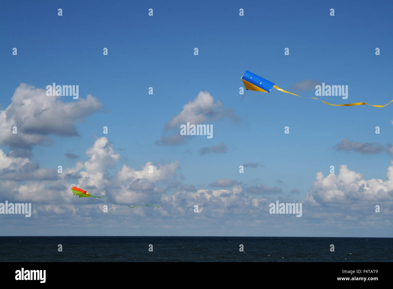 Two kites flying over sea and cloudy sky background Stock Photo - Alamy