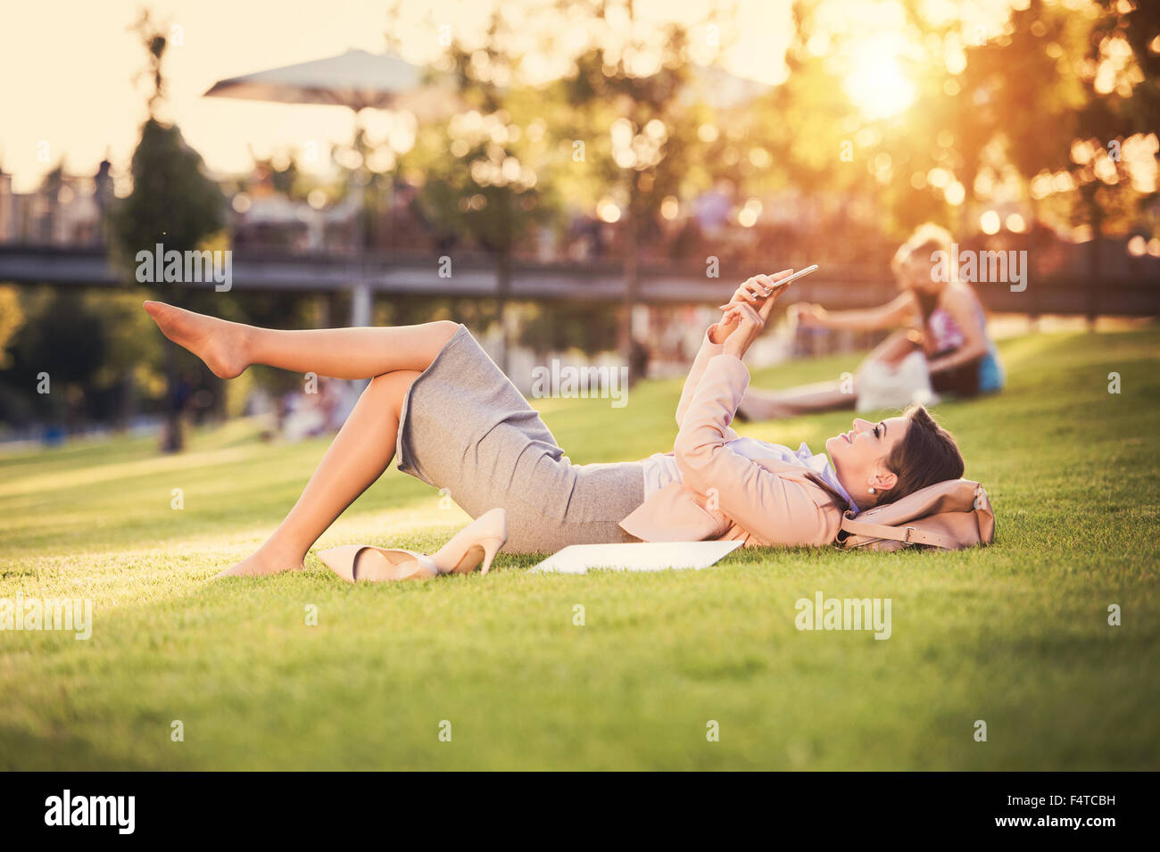 Business woman sitting in a park Stock Photo - Alamy