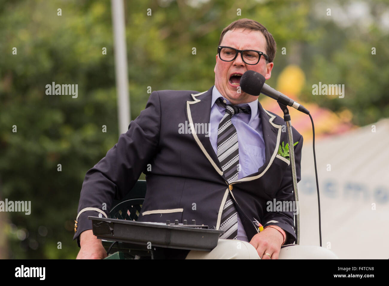 A tennis umpire shouts into a microphone upon his high seat at a match ...