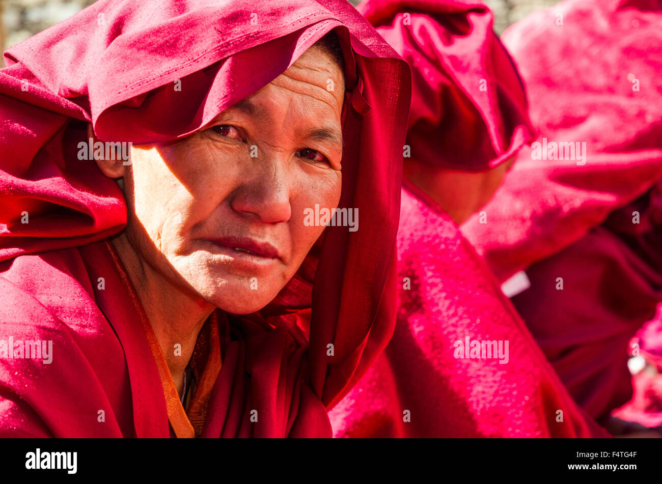 Portrait of a nun wearing red cloths sitting within other nuns Stock ...