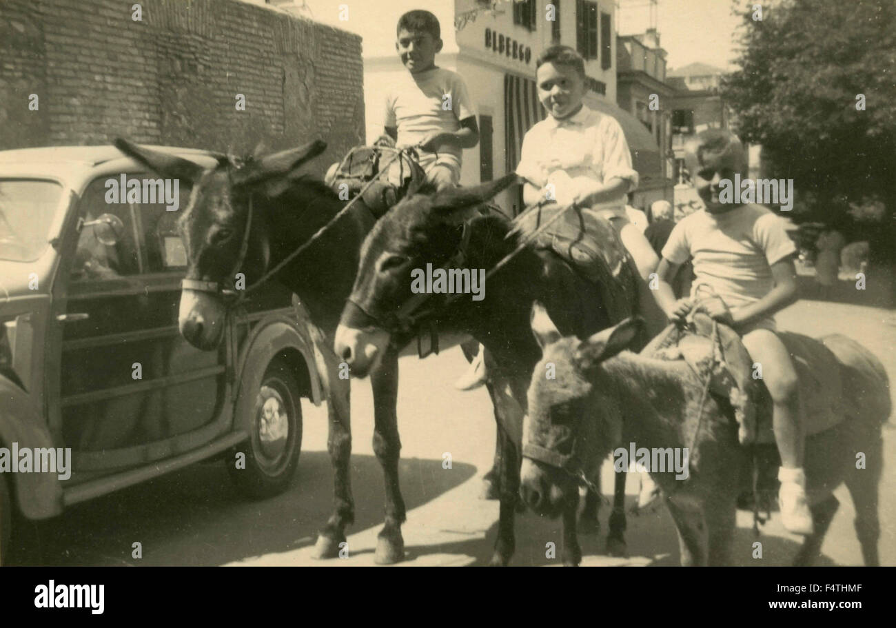 Three children on donkeys in Rocca di Papa, Italy Stock Photo - Alamy